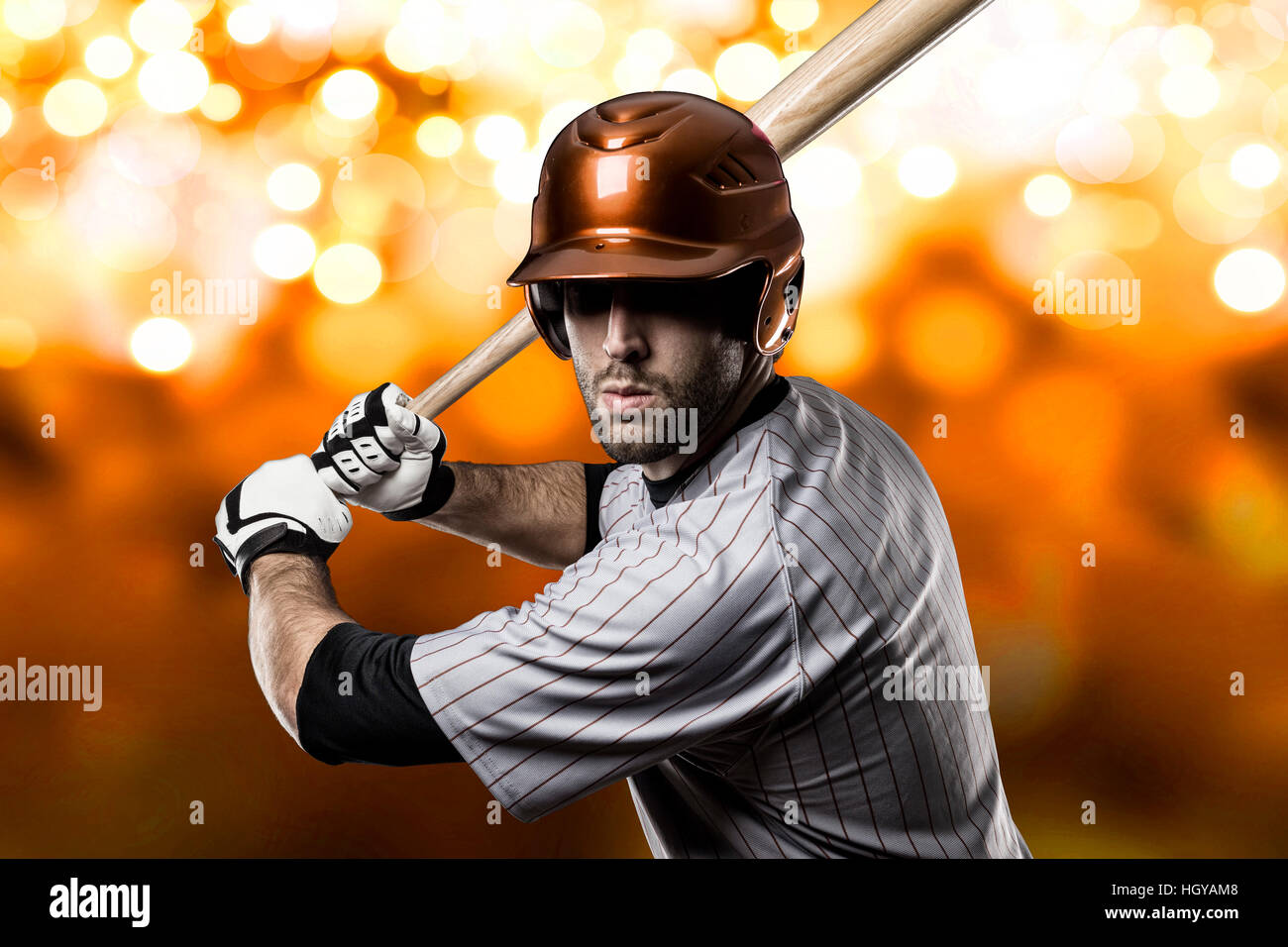 Baseball Player on a orange Uniform on orange lights background Stock ...