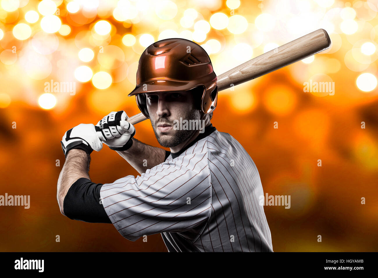 Baseball Player on a orange Uniform on orange lights background Stock ...