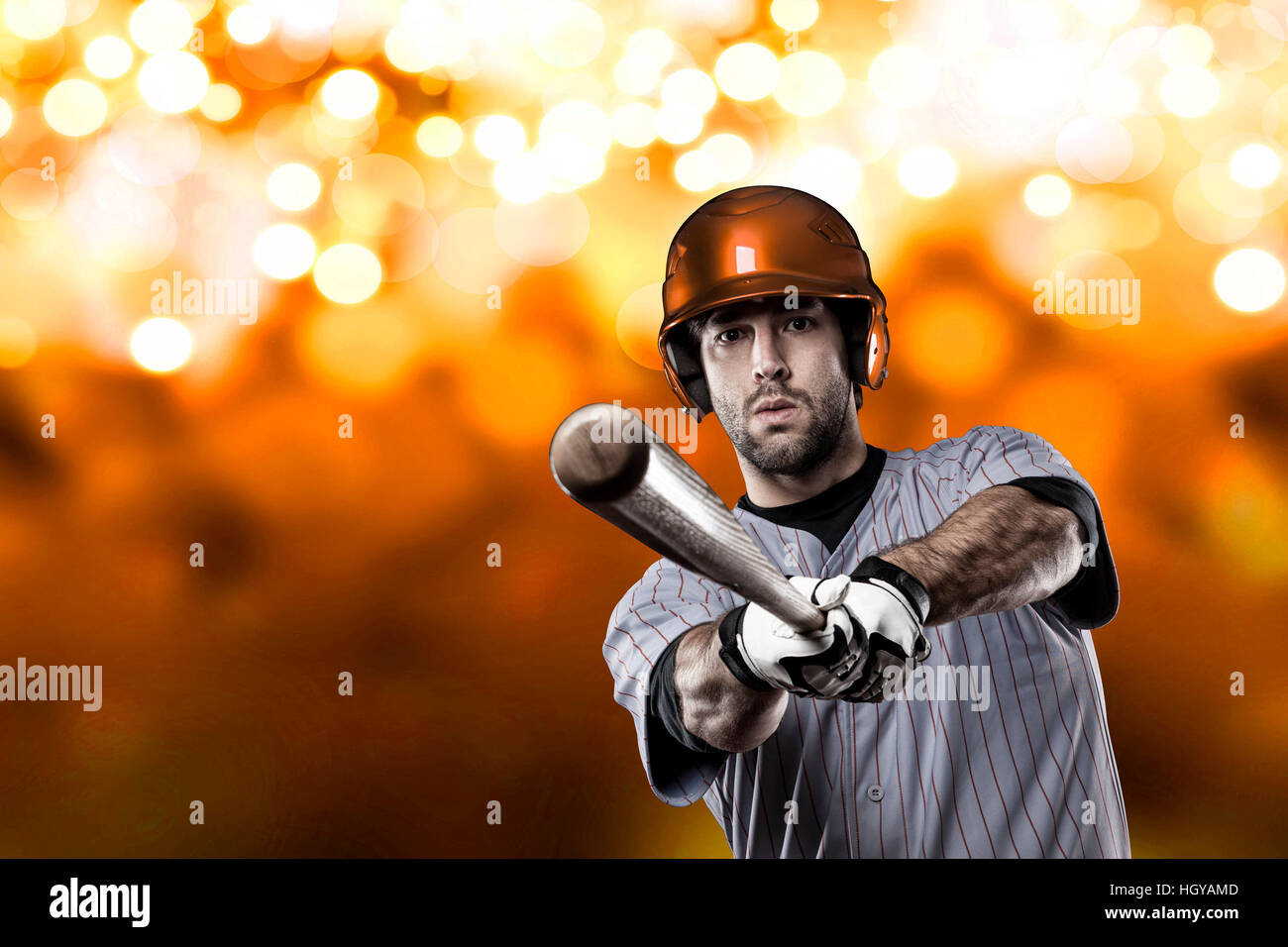 Baseball Player on a orange Uniform on orange lights background Stock ...