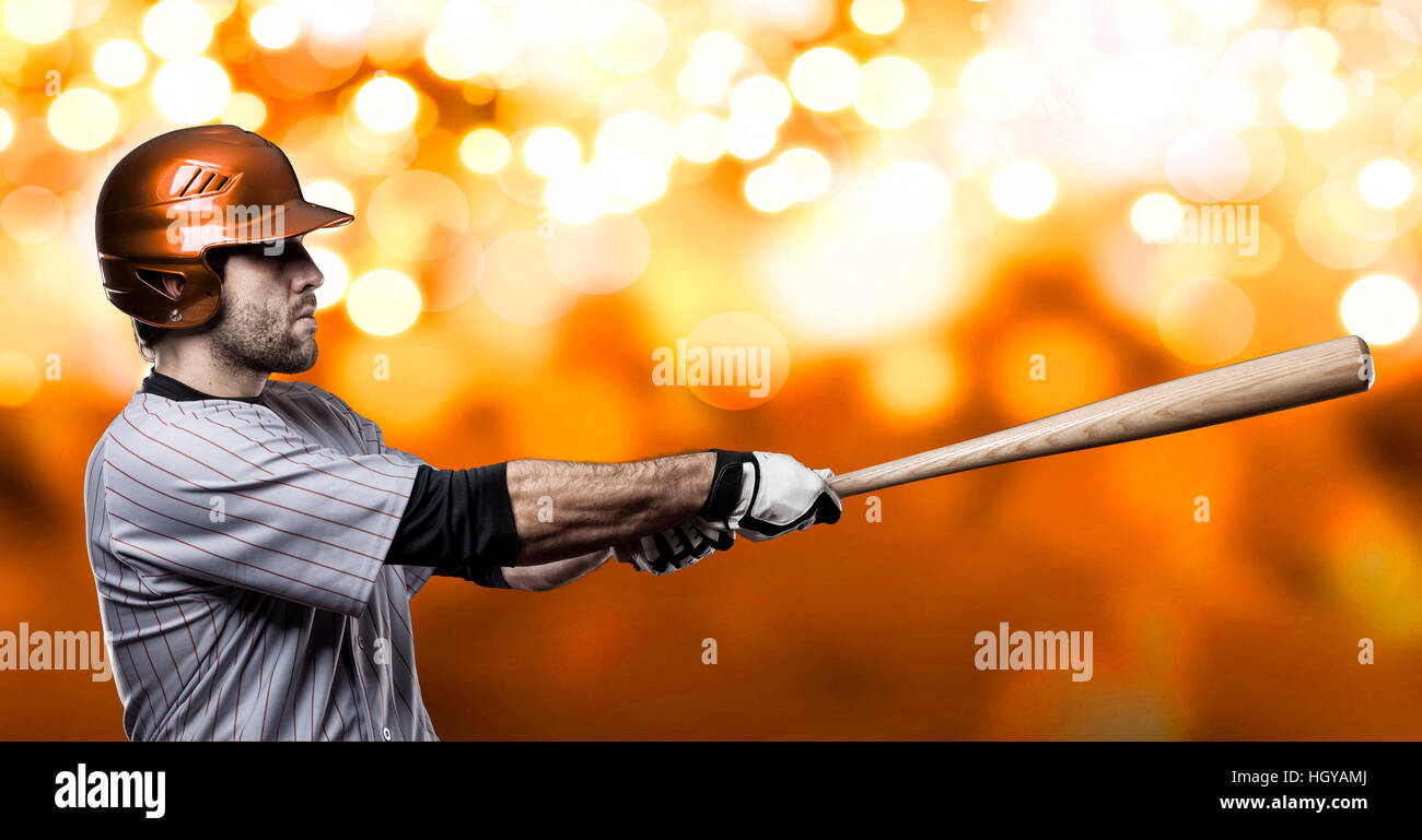 Baseball Player on a orange Uniform on orange lights background Stock ...