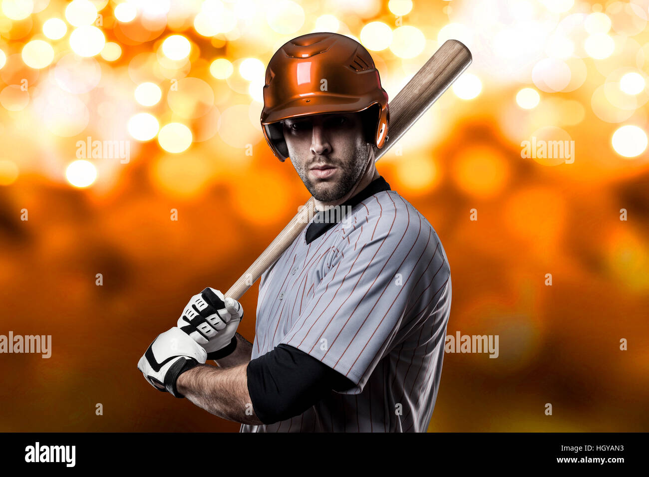 Baseball Player on a orange Uniform on orange lights background Stock ...