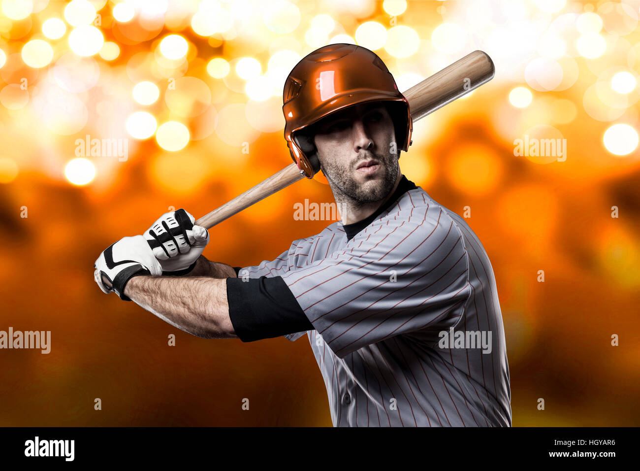 Baseball Player on a orange Uniform on orange lights background Stock ...