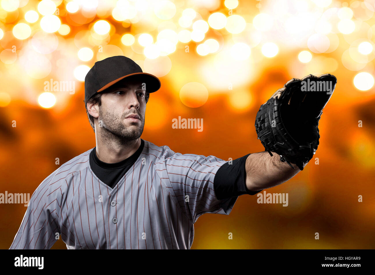Baseball Player on a orange Uniform on orange lights background Stock ...
