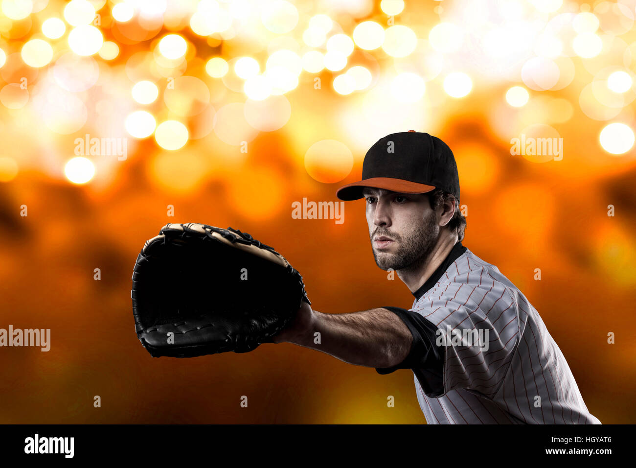 Baseball Player on a orange Uniform on orange lights background Stock ...