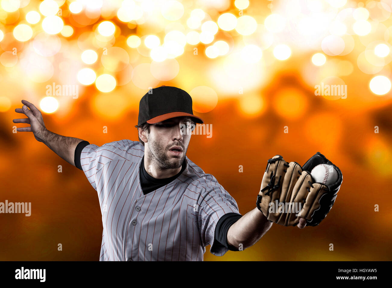 Baseball Player on a orange Uniform on orange lights background Stock ...