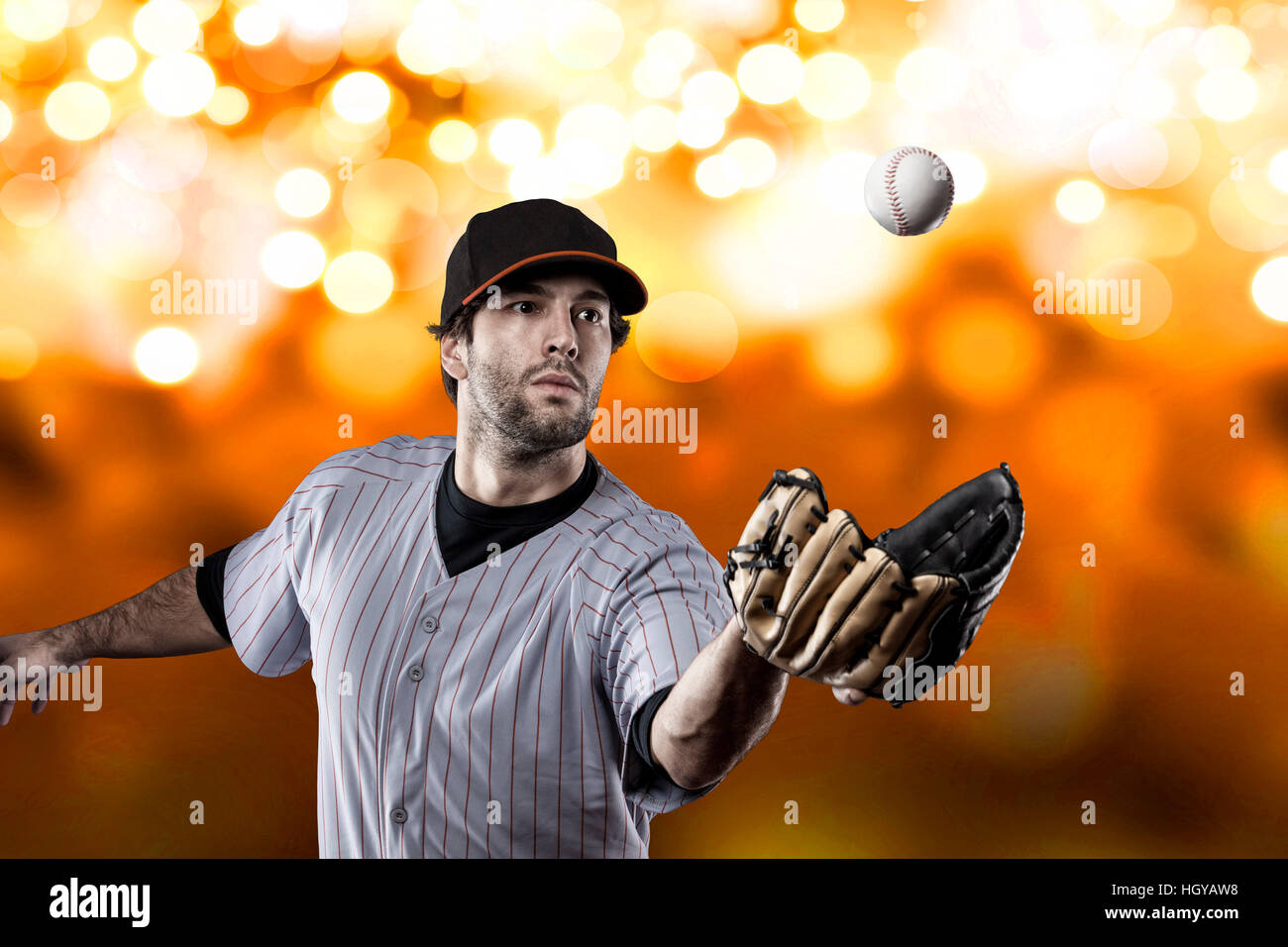 Baseball Player on a orange Uniform on orange lights background Stock ...
