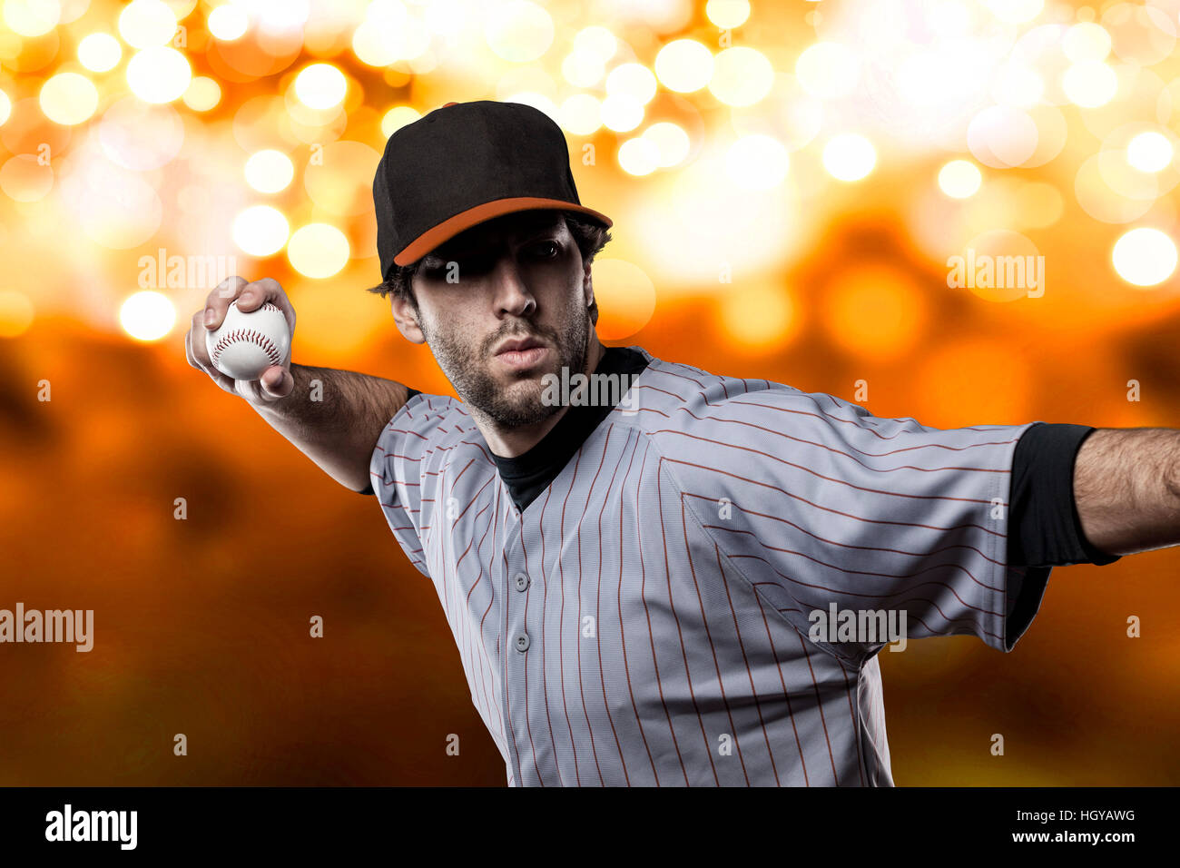 Baseball Player on a orange Uniform on orange lights background Stock ...