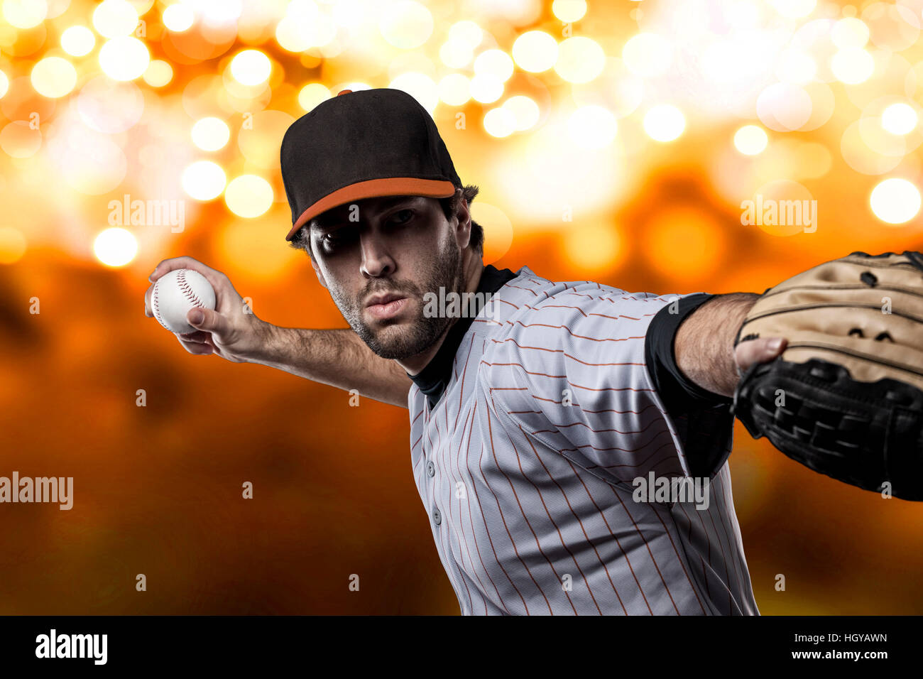Baseball Player on a orange Uniform on orange lights background Stock ...