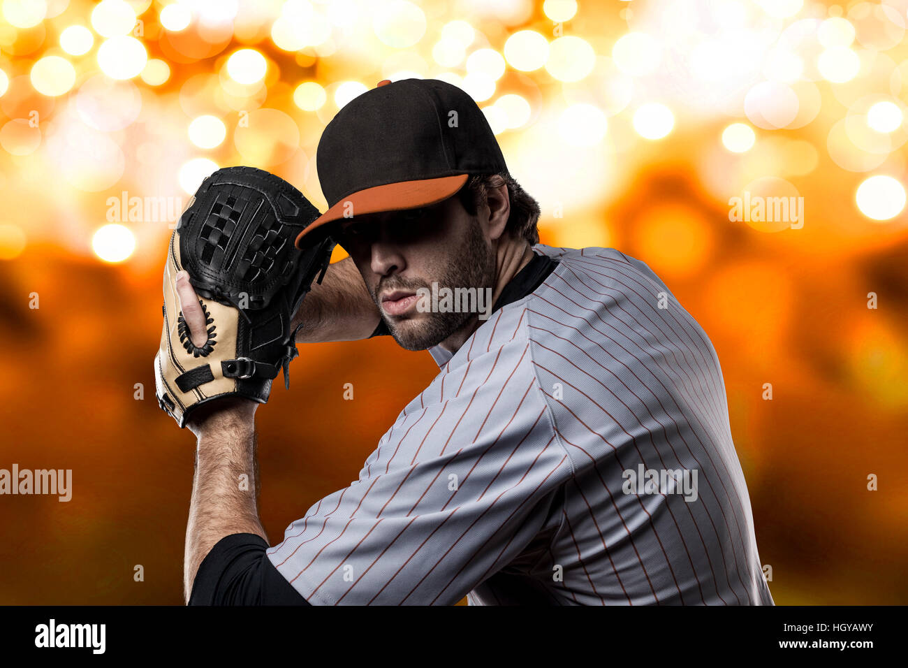 Baseball Player on a orange Uniform on orange lights background Stock ...