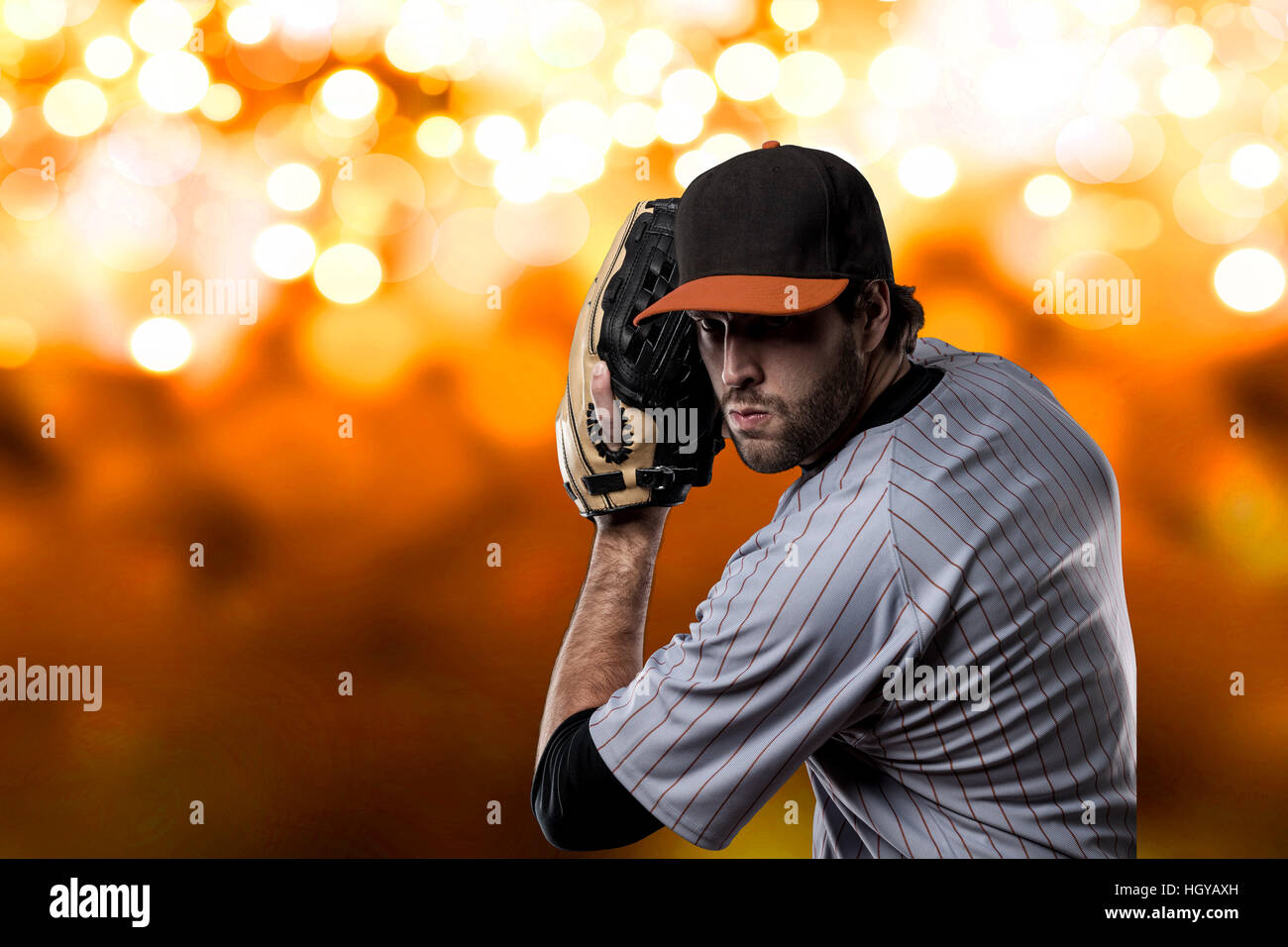 Baseball Player on a orange Uniform on orange lights background Stock ...
