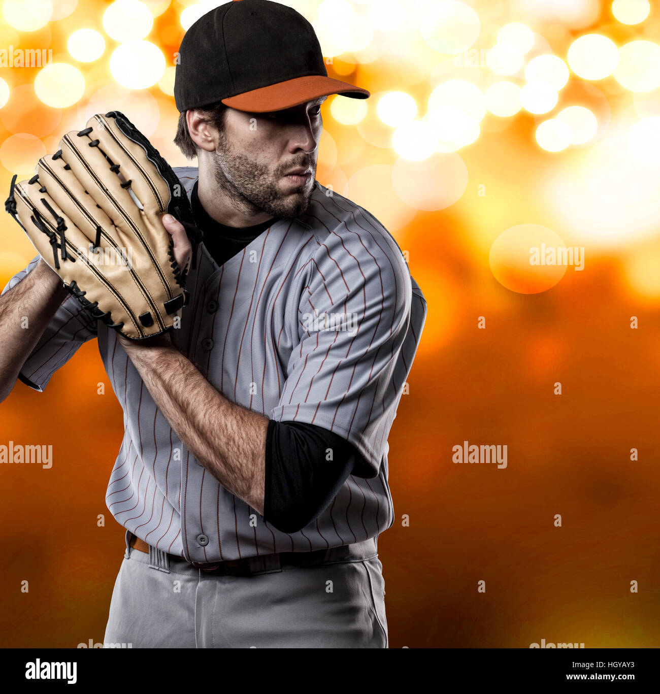 Baseball Player on a orange Uniform on orange lights background Stock ...