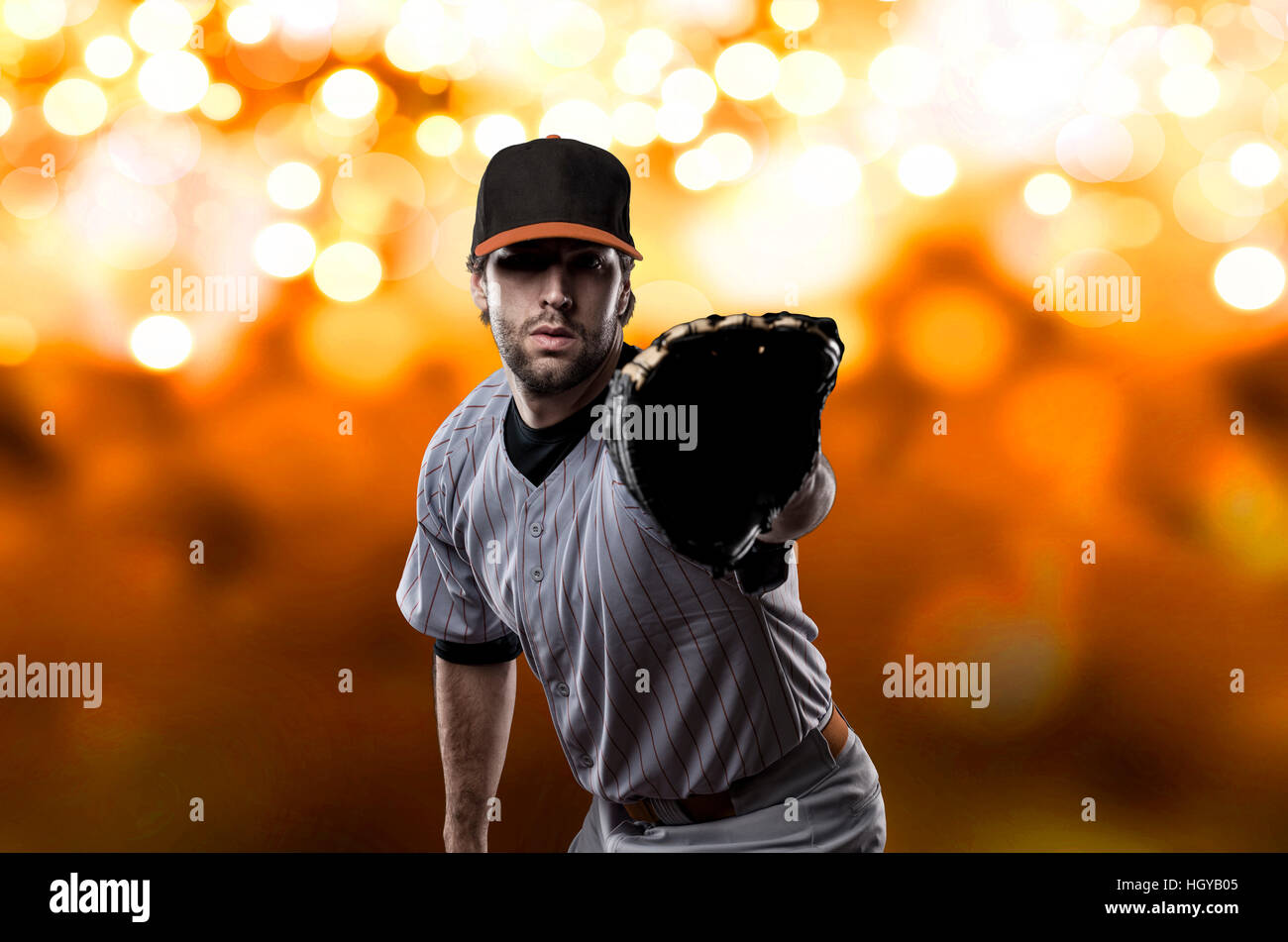 Baseball Player on a orange Uniform on orange lights background Stock ...
