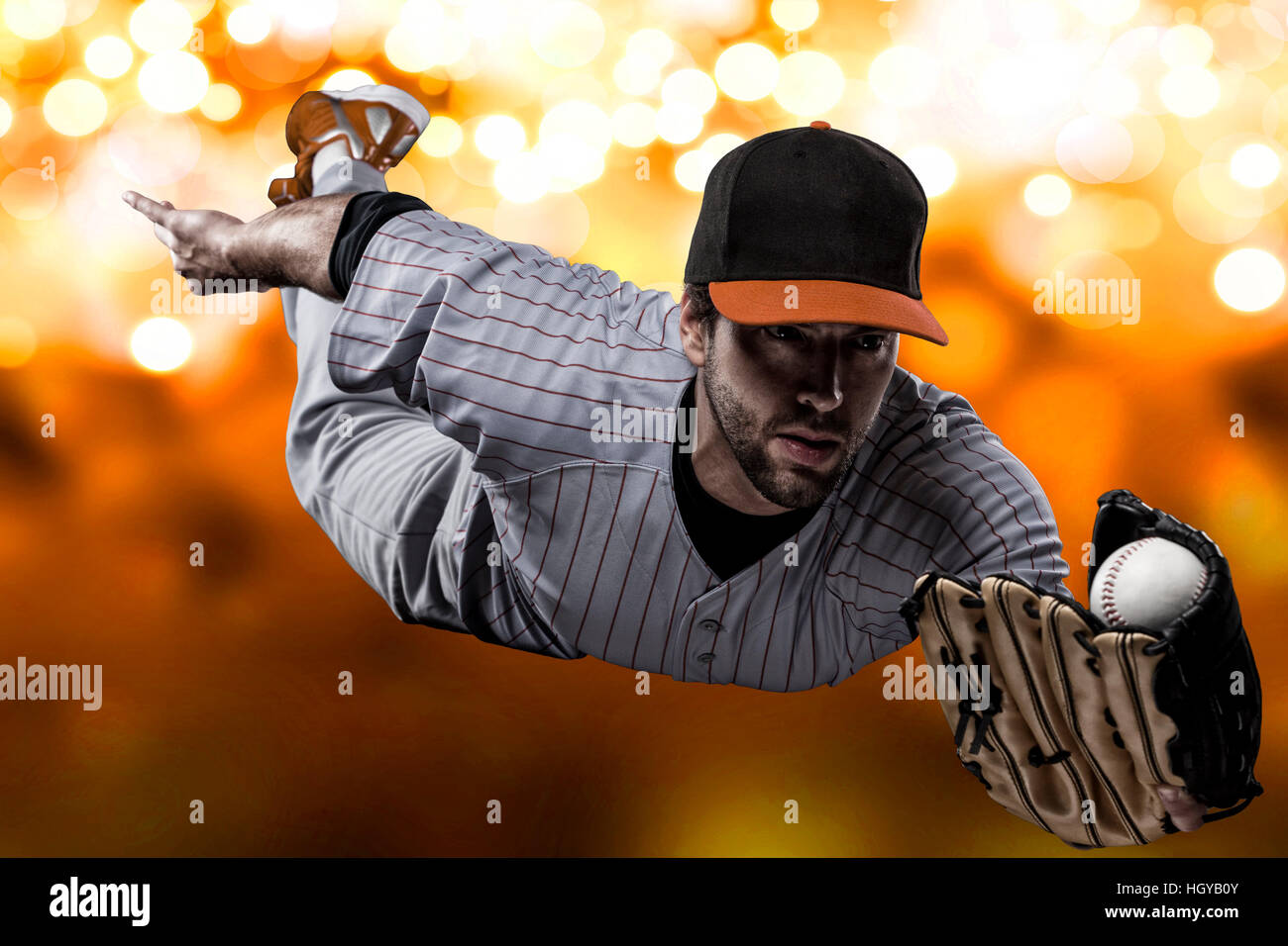 Baseball Player on a orange Uniform on orange lights background Stock ...