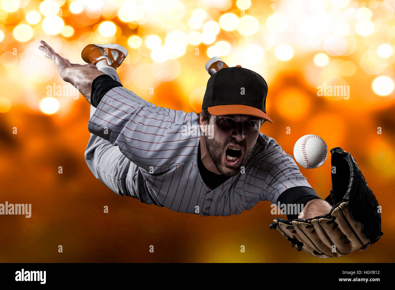 Baseball Player on a orange Uniform on orange lights background Stock ...