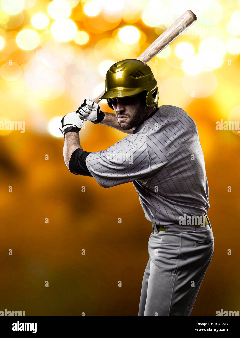 Baseball Player on a yellow Uniform on yellow lights background Stock ...