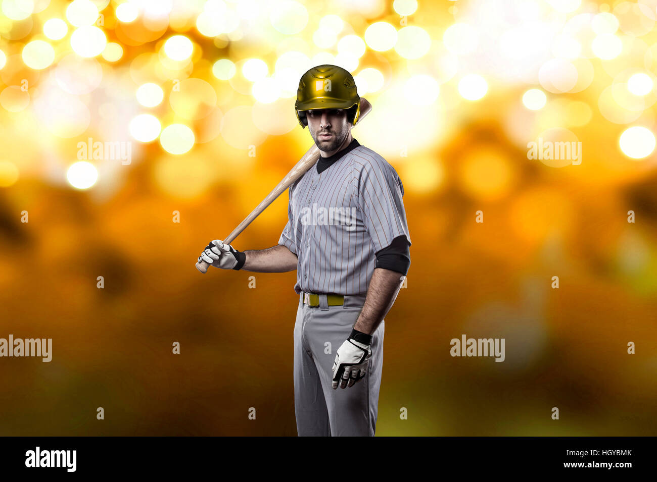 Baseball Player on a yellow Uniform on yellow lights background Stock ...
