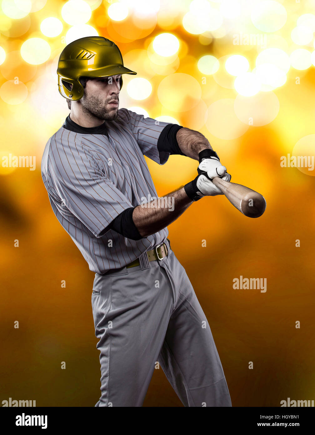 Baseball Player on a yellow Uniform on yellow lights background Stock ...