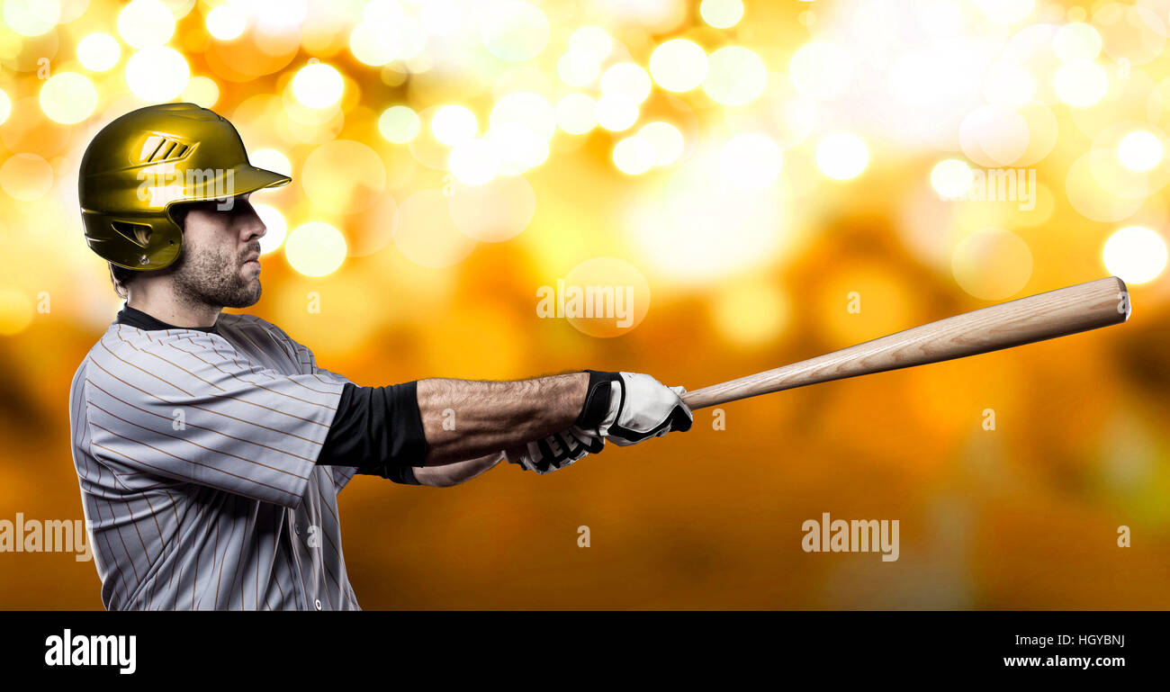 Baseball Player on a yellow Uniform on yellow lights background Stock ...