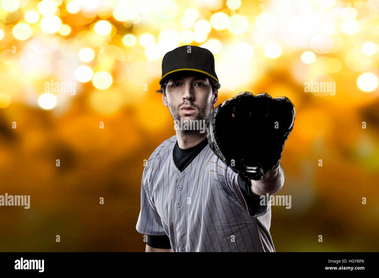Baseball Player on a yellow Uniform on yellow lights background Stock ...