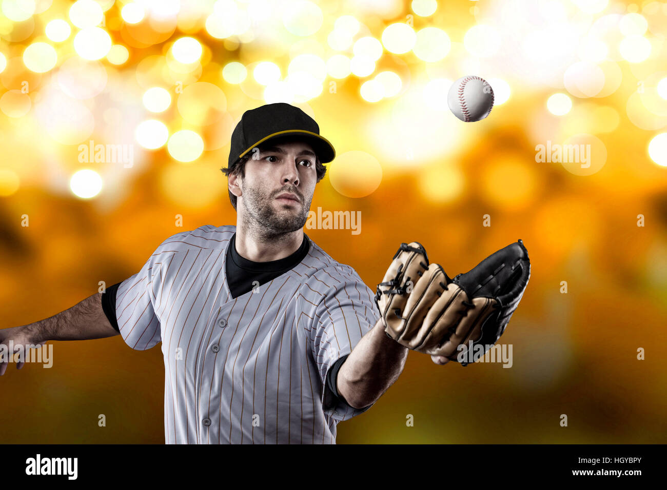 Baseball Player on a yellow Uniform on yellow lights background Stock ...
