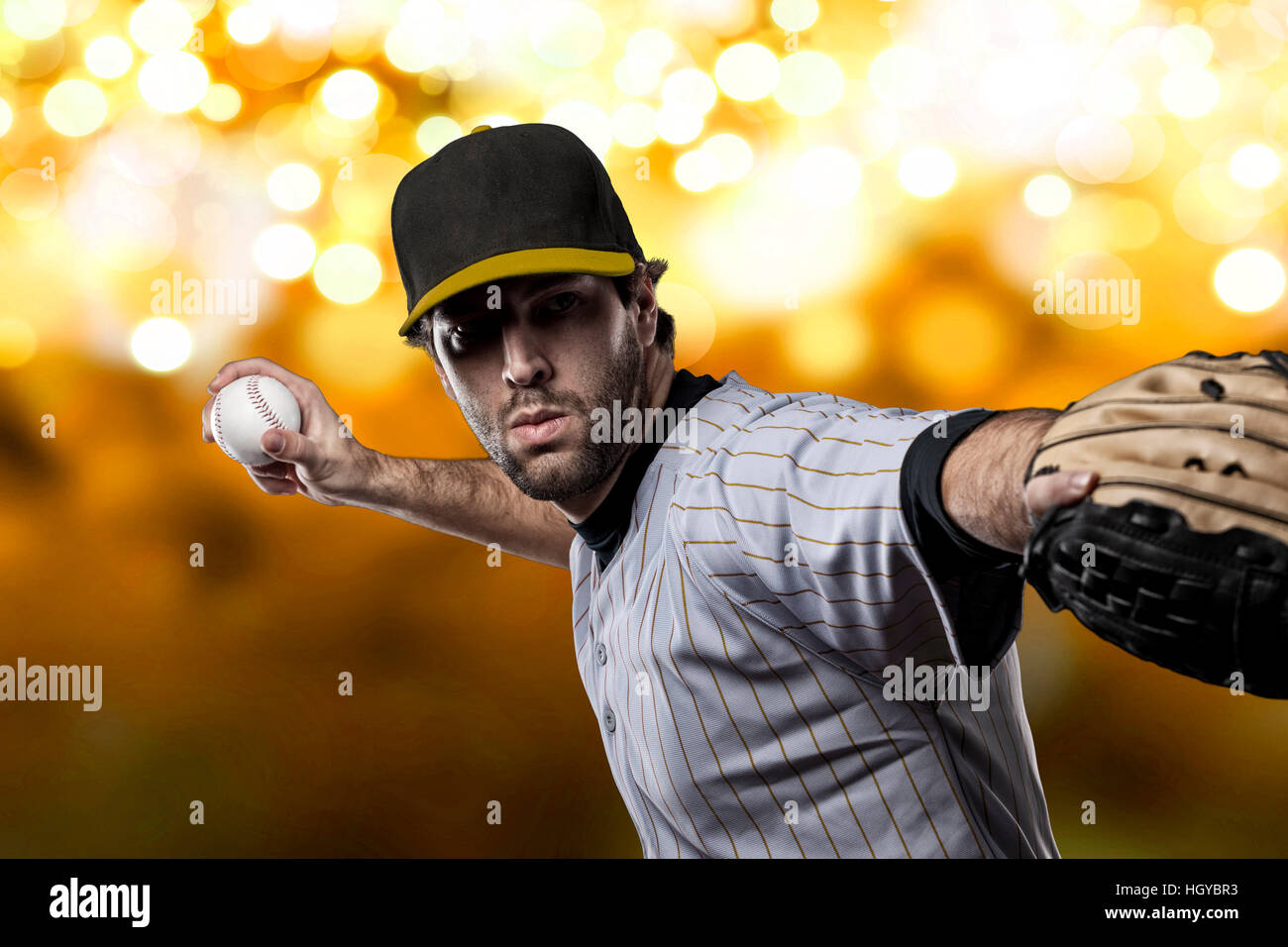 Baseball Player on a yellow Uniform on yellow lights background Stock ...