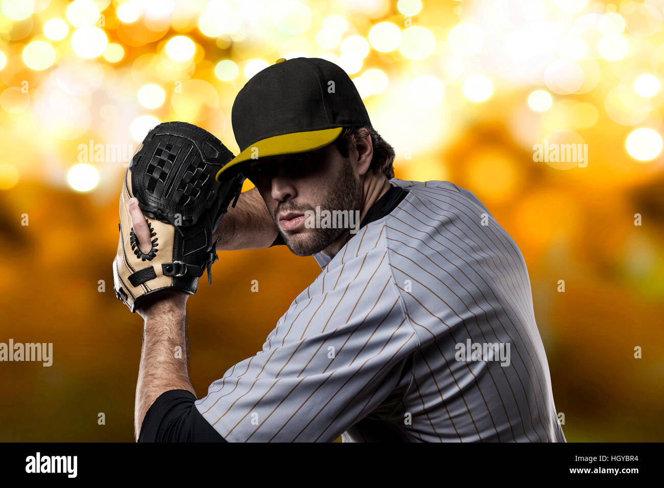 Baseball Player on a yellow Uniform on yellow lights background Stock ...