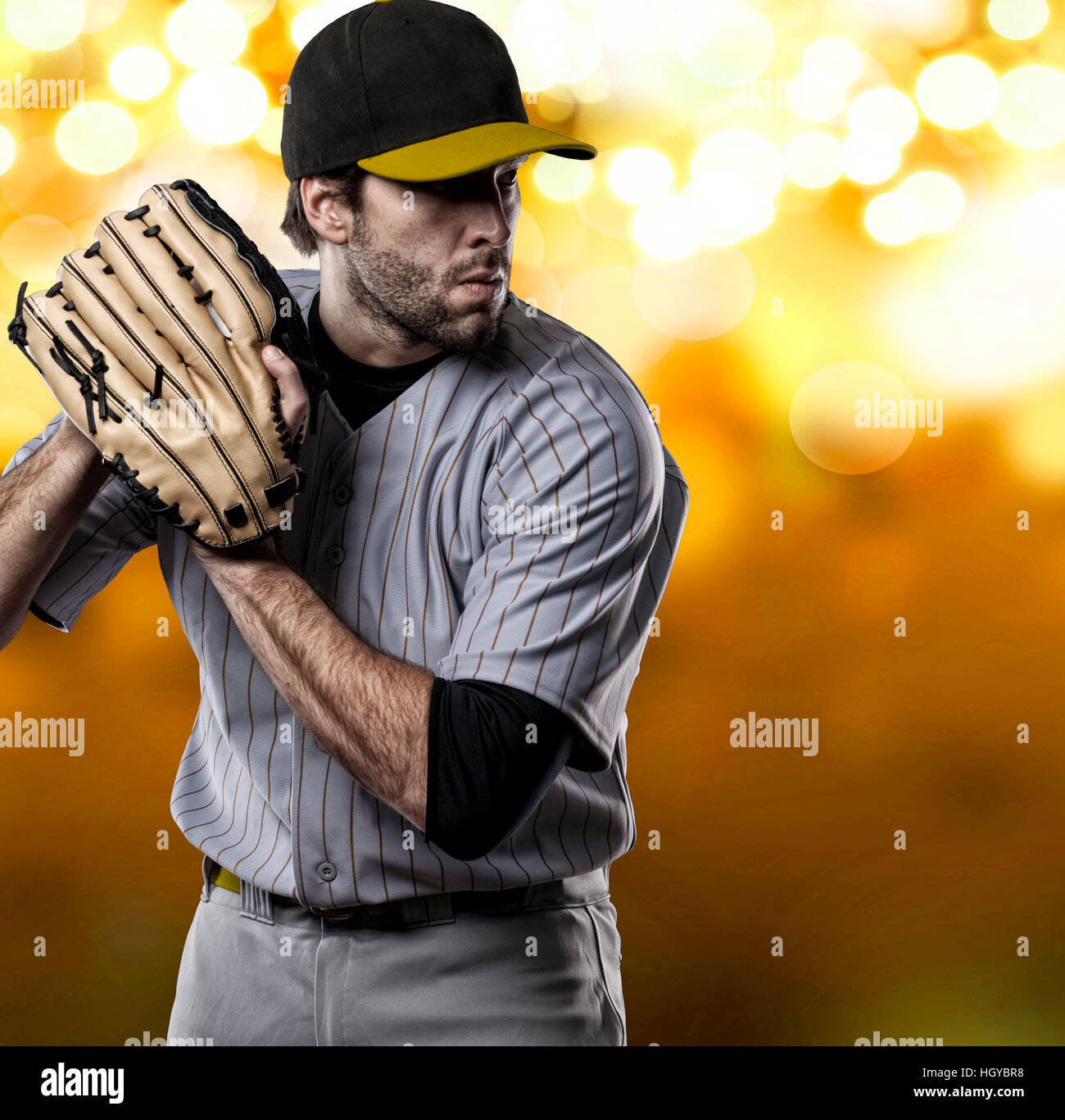 Baseball Player on a yellow Uniform on yellow lights background Stock ...