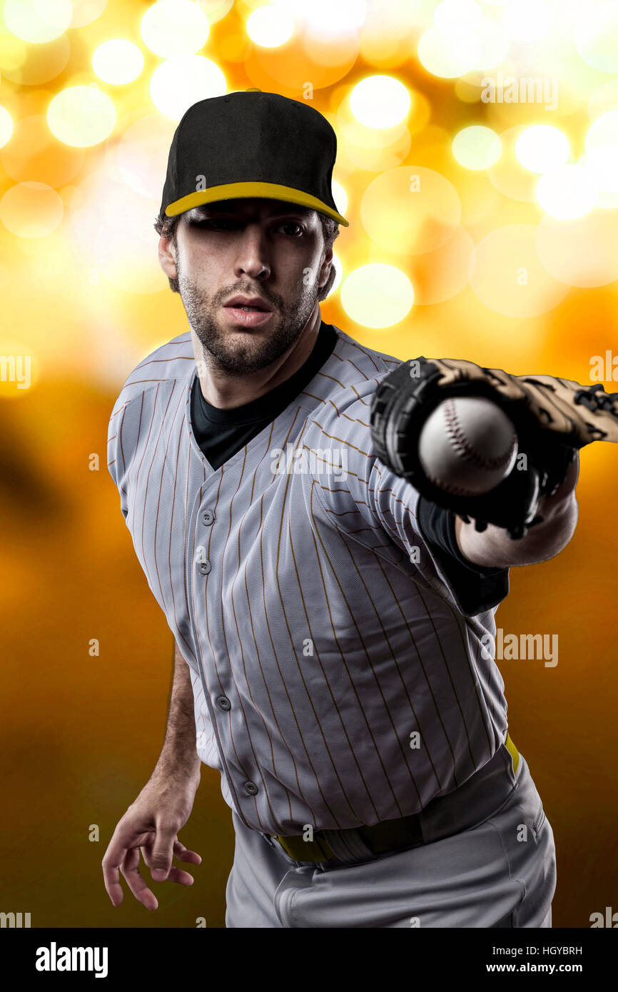 Baseball Player on a yellow Uniform on yellow lights background Stock ...