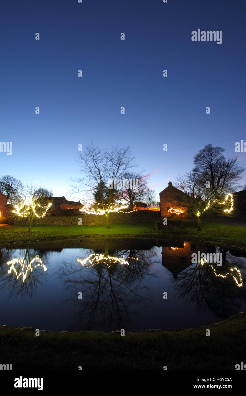 Christmas lights around the village pond on the green in Foolow, PEak ...