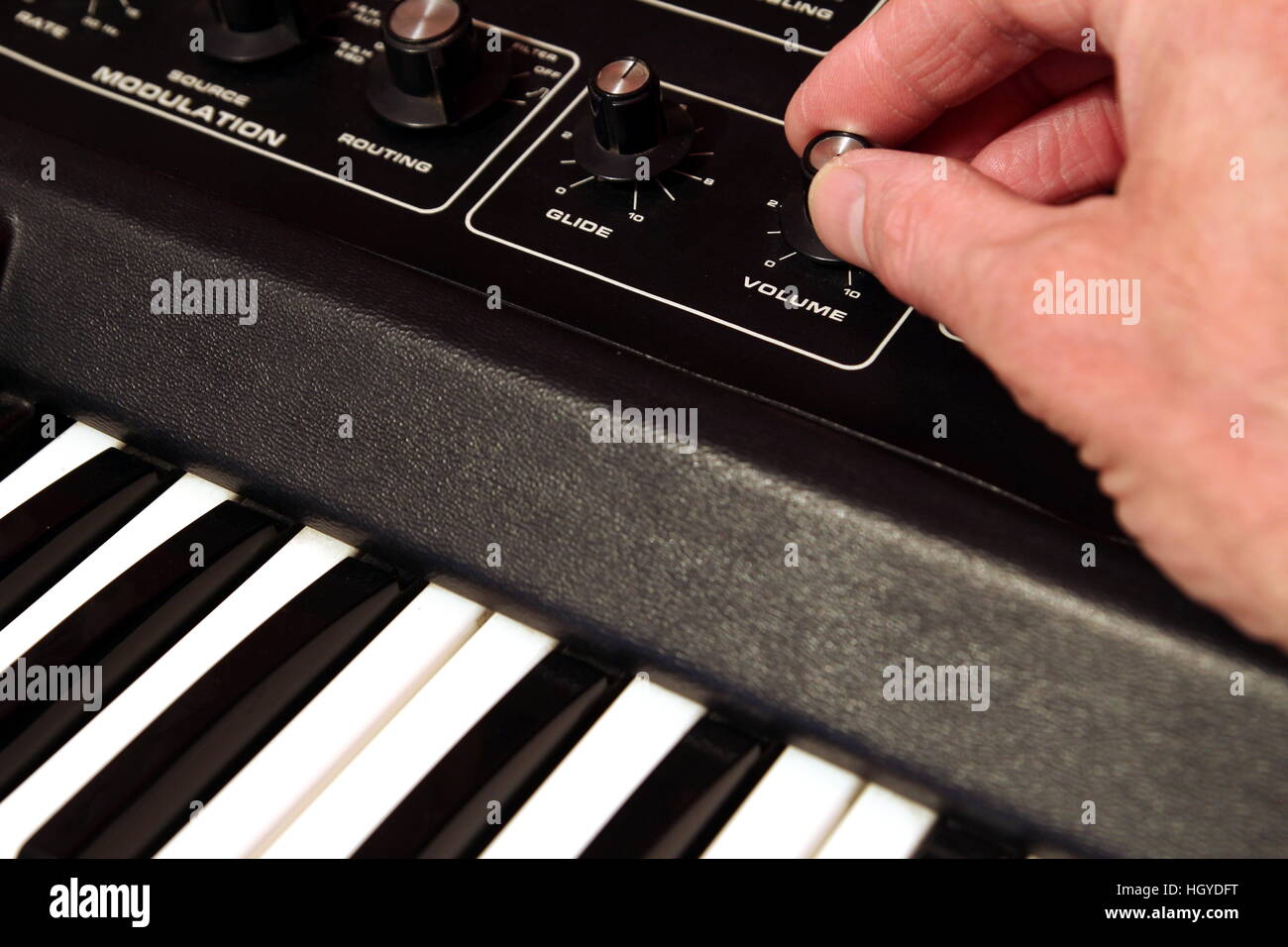 Man's hand adjusting the volume on a vintage analog synth Stock Photo ...
