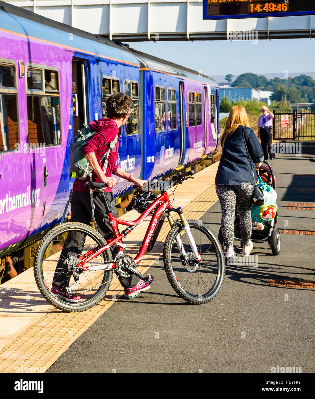 Woman with bicycle disembarking from train at Buckshaw Parkway near ...