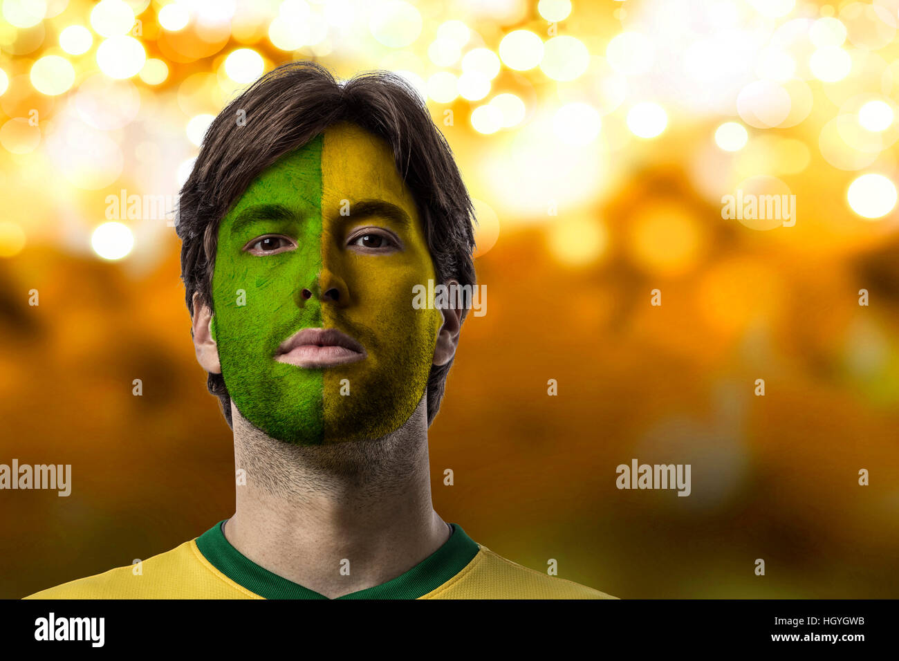 Brazilian fan with paint on his face celebrating on a yellow lights ...