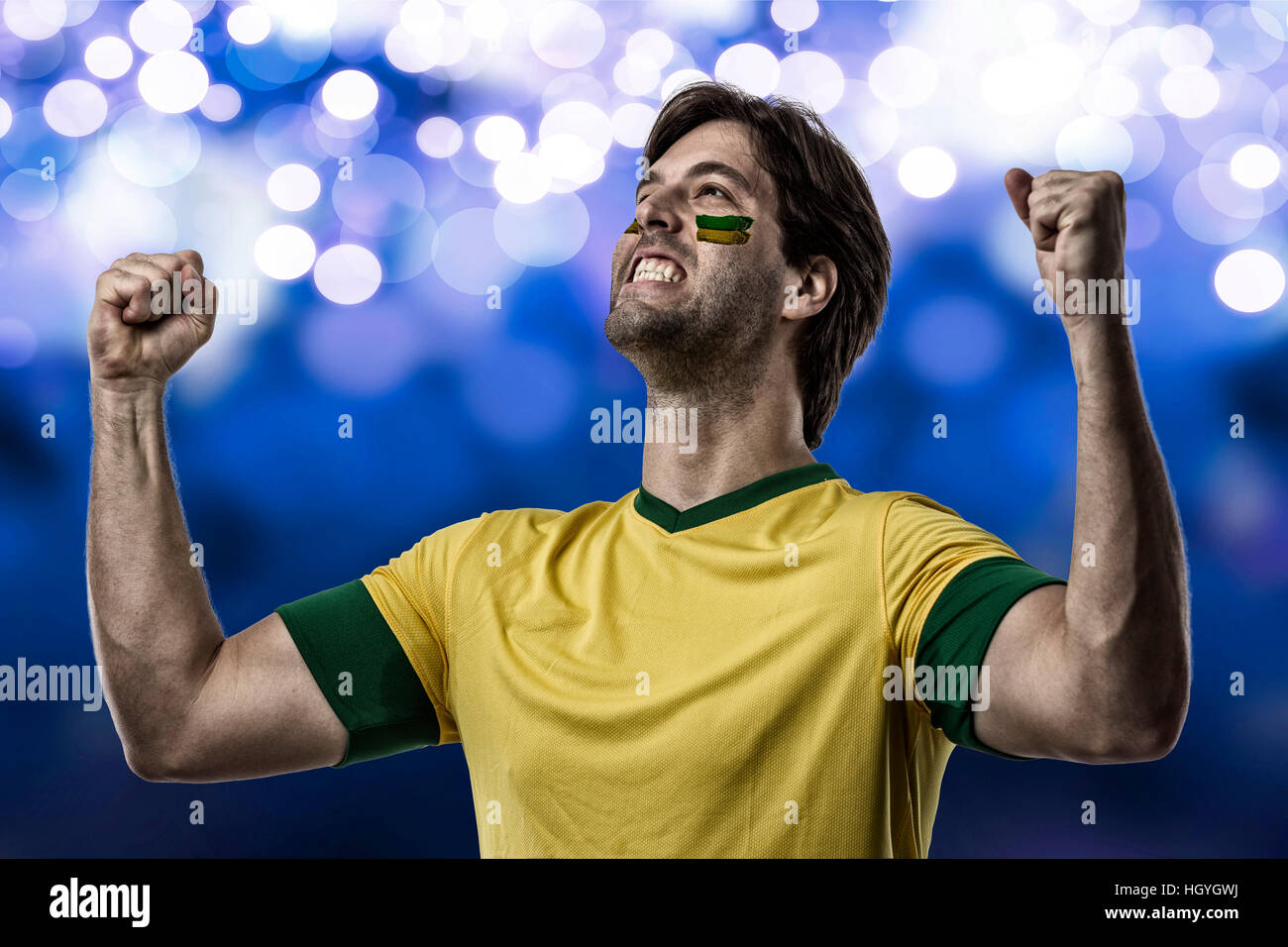 Brazilian fan with paint on his face celebrating on a blue lights ...