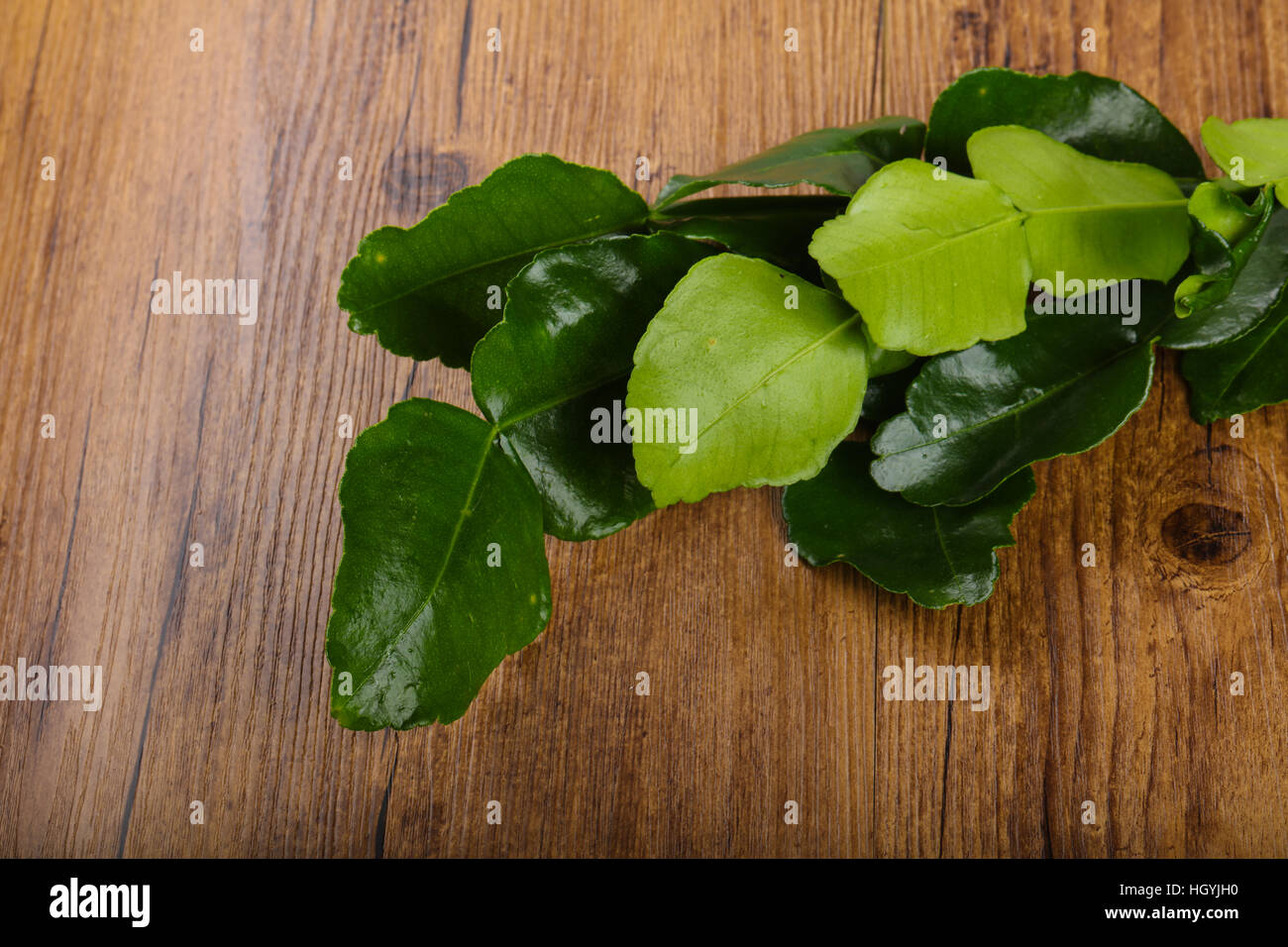 Kafir lime leaves on the wood background Stock Photo - Alamy