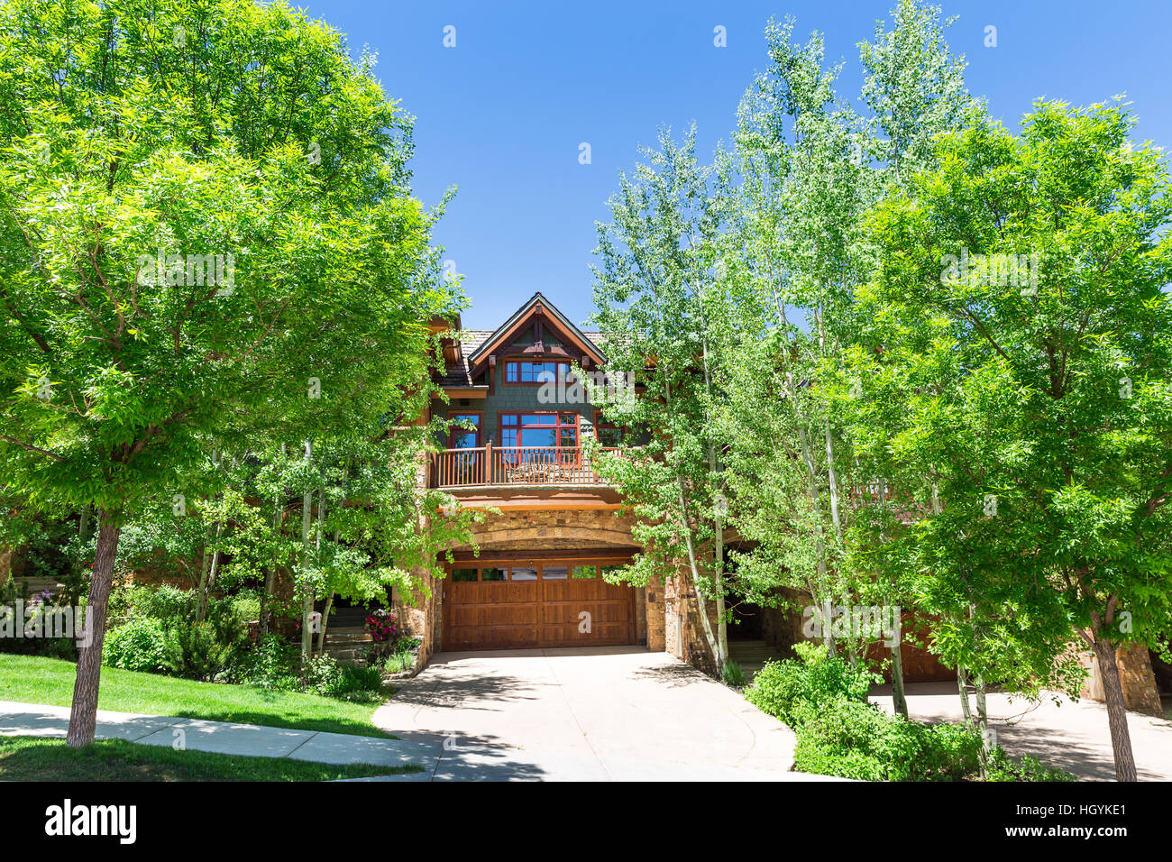 Wooden house with trees around it in sunny day Stock Photo - Alamy