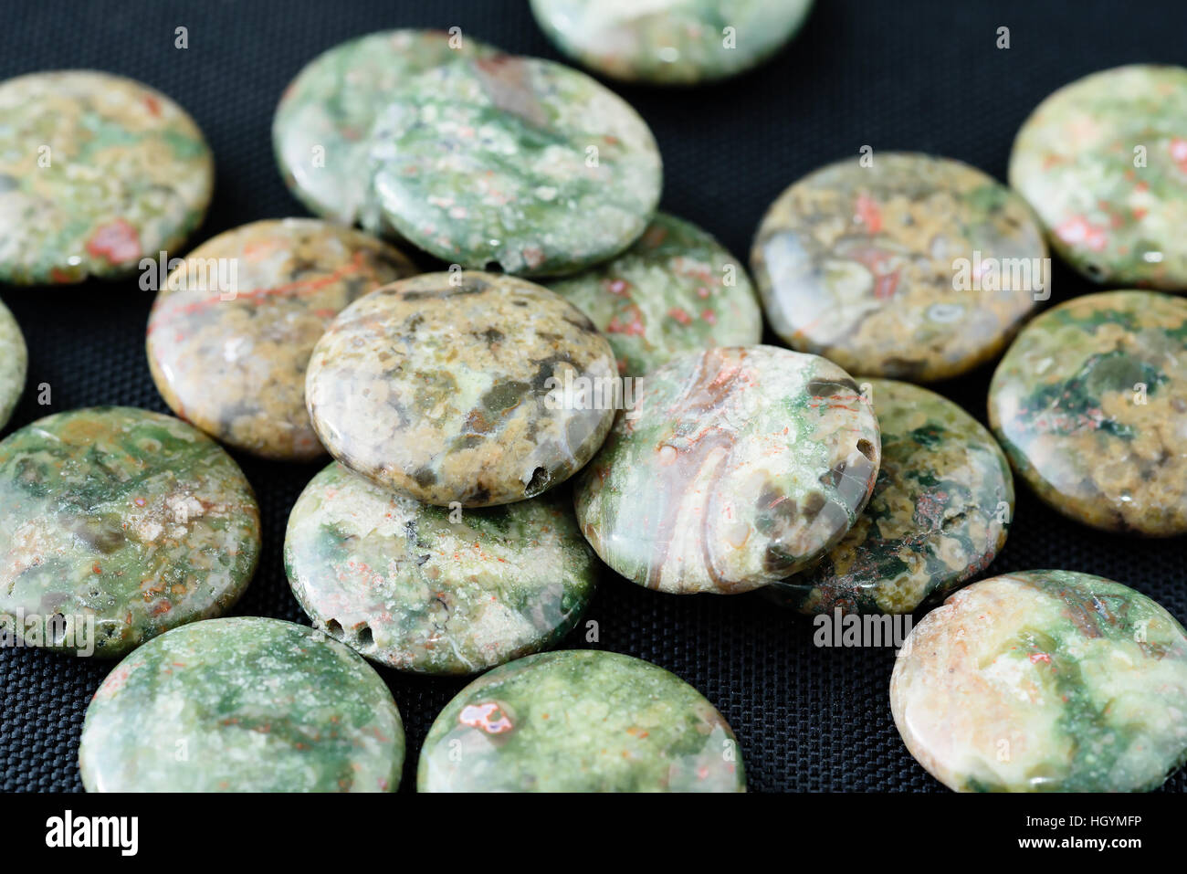 Green marbled agate coin shaped beads on black weave Stock Photo - Alamy