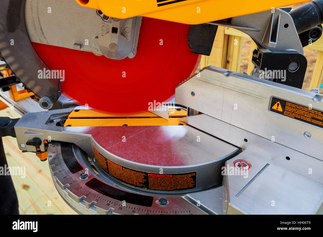 Carpenter cutting wooden plank with circular saw wearing safety ...