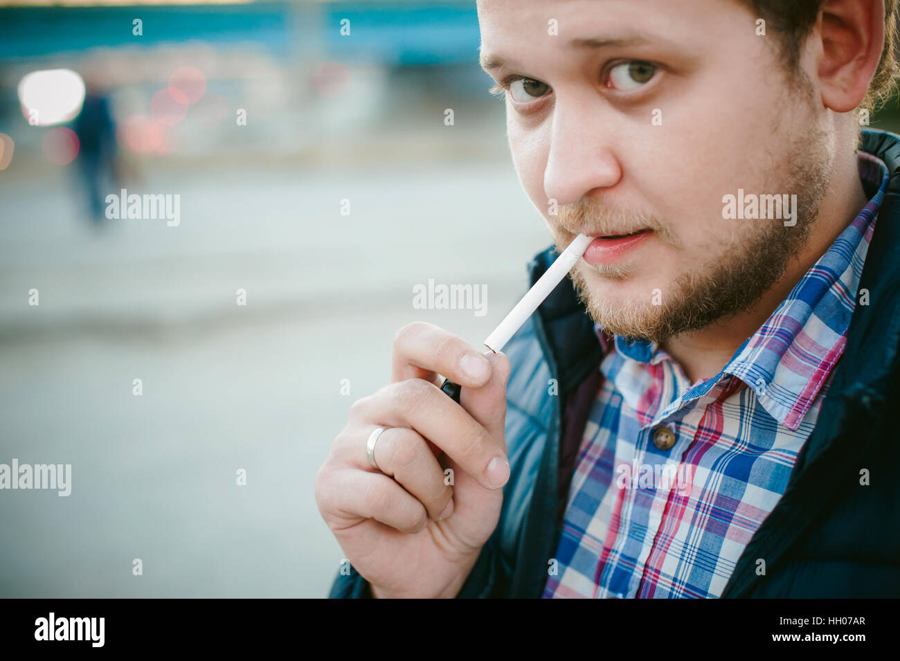 man pulls a cigarette from the pack and lights up Stock Photo - Alamy
