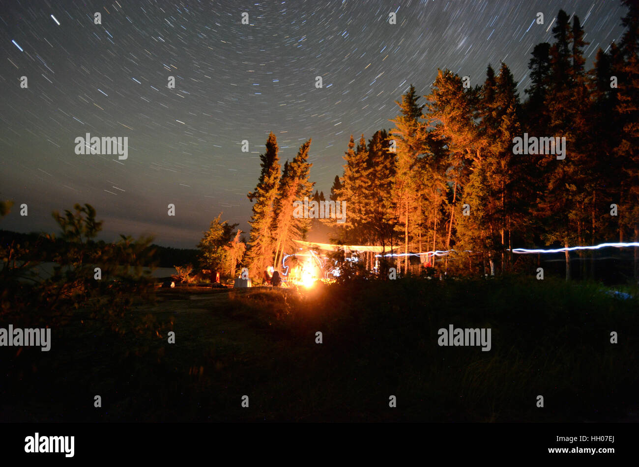 A campfire burns bright while stars swirls overhead Stock Photo - Alamy