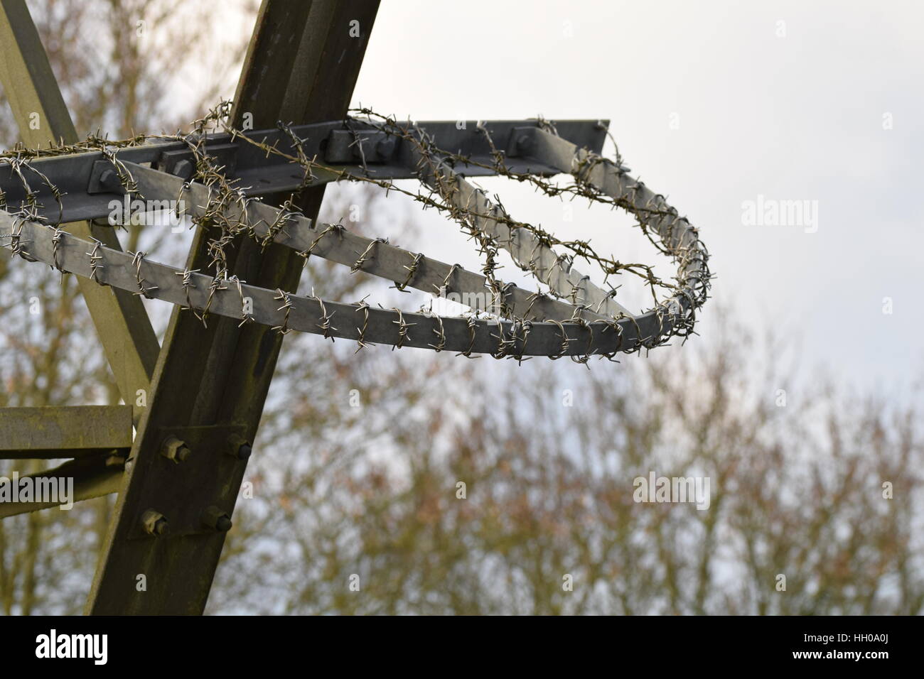 Barbed wire around base of electricity pylons Stock Photo - Alamy