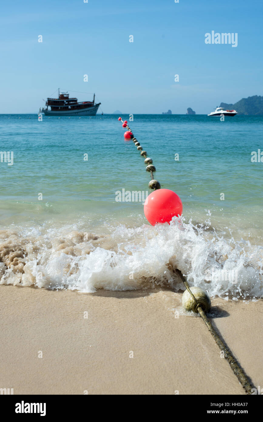 String of marker buoys is anchored on the beach, drifted by the sea ...