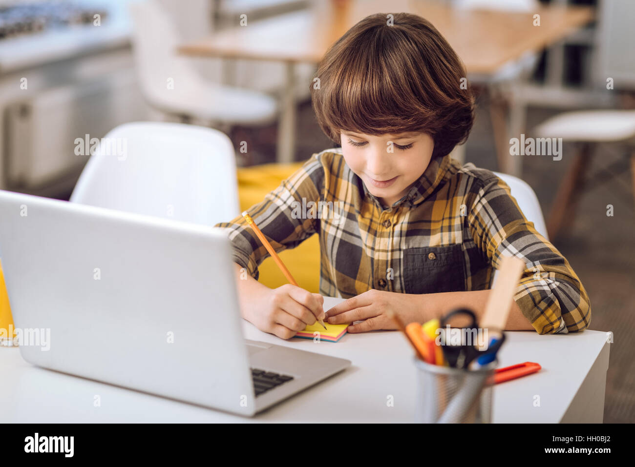 Little boy writing notes with pensil Stock Photo - Alamy