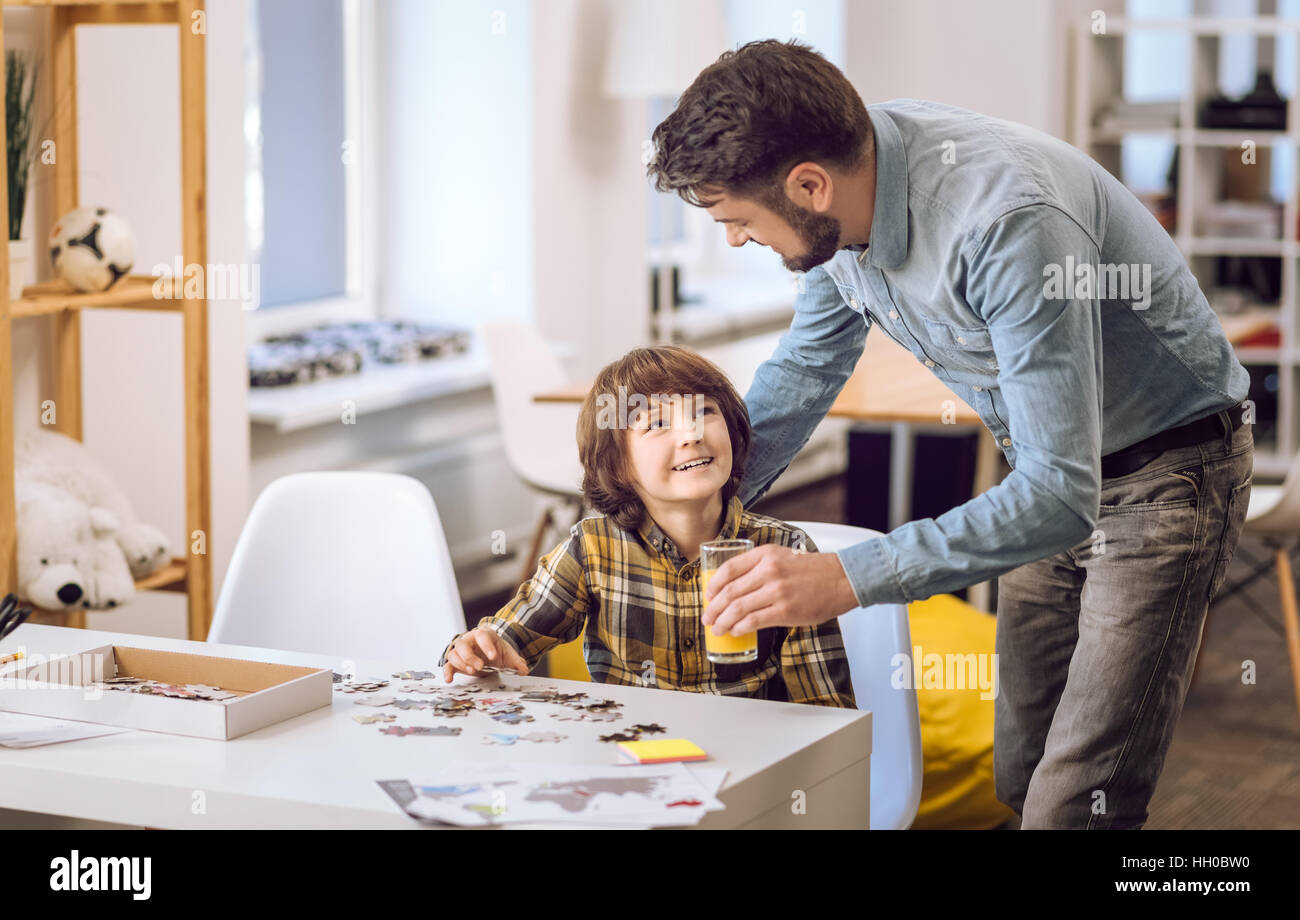 Attentive father giving a glass of juice to his son Stock Photo - Alamy