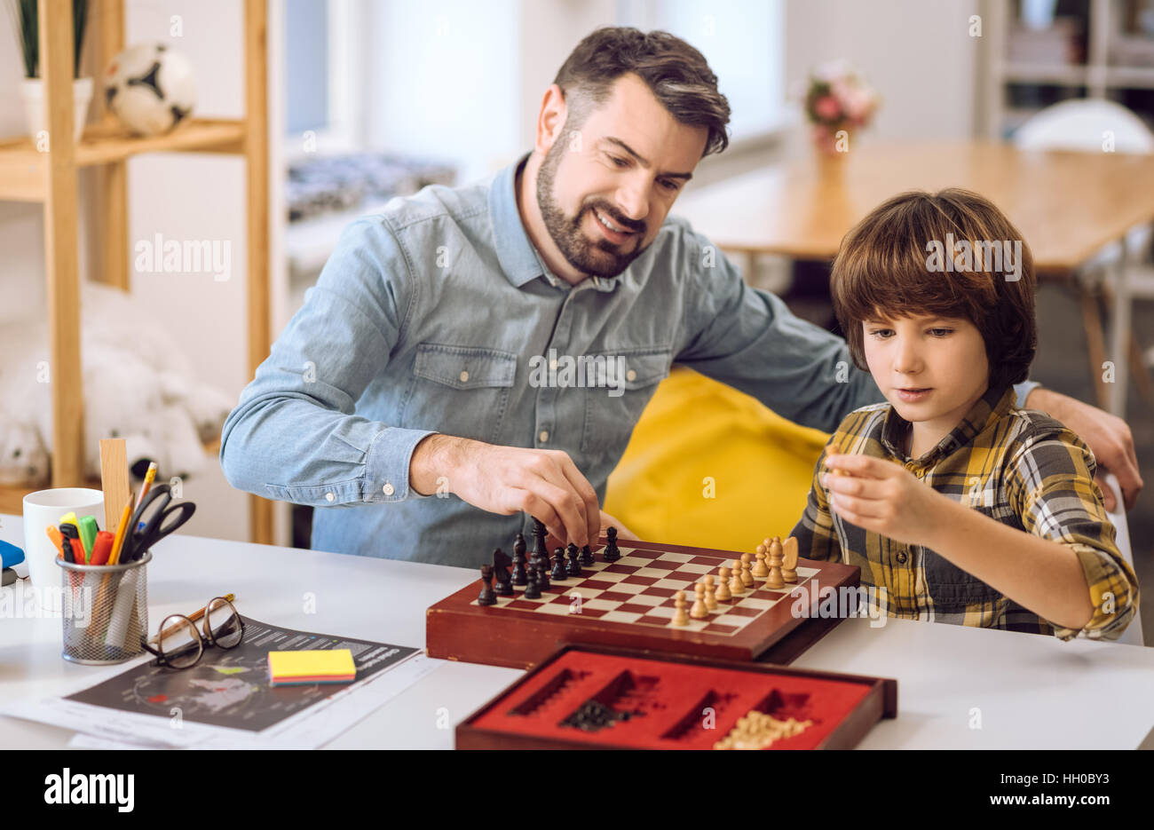 Positive delighted friends playing chess Stock Photo - Alamy