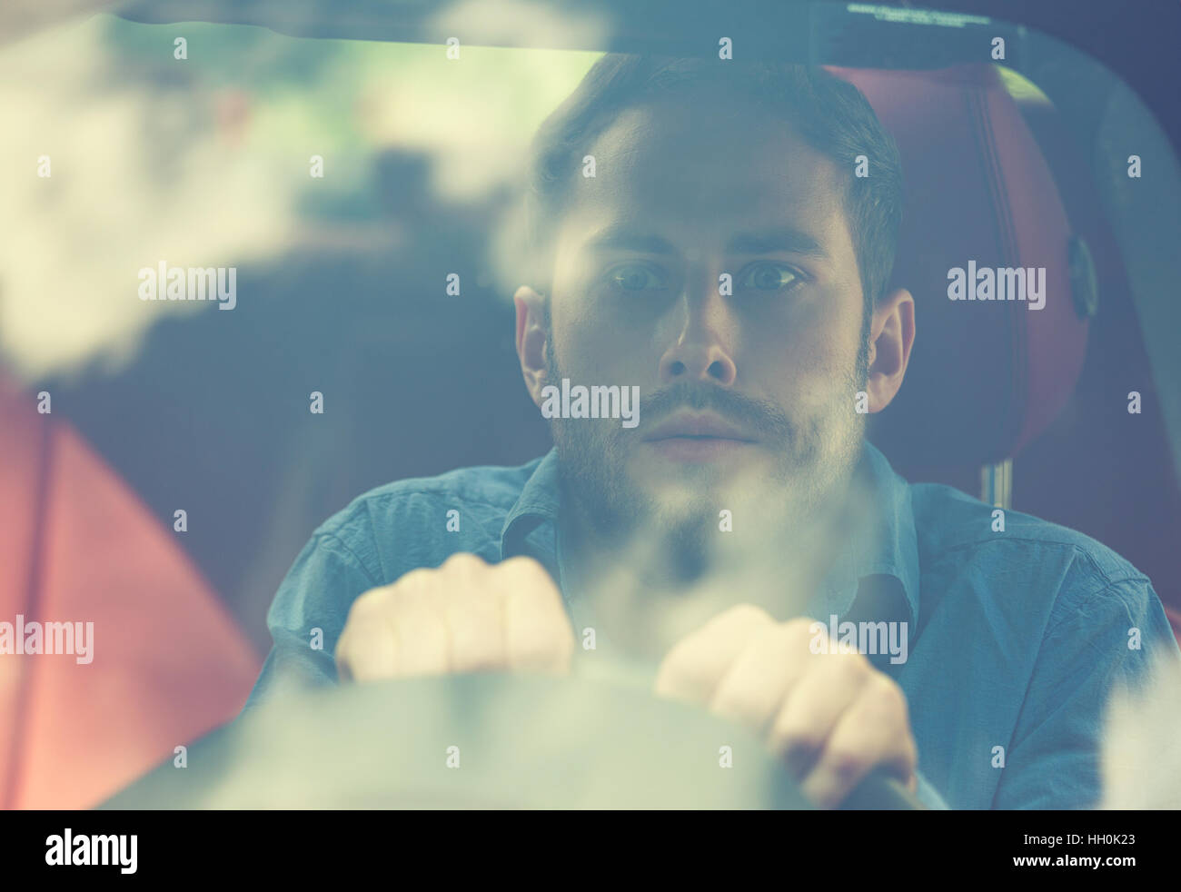 shocked scared funny looking young driver in the car. Human emotion ...