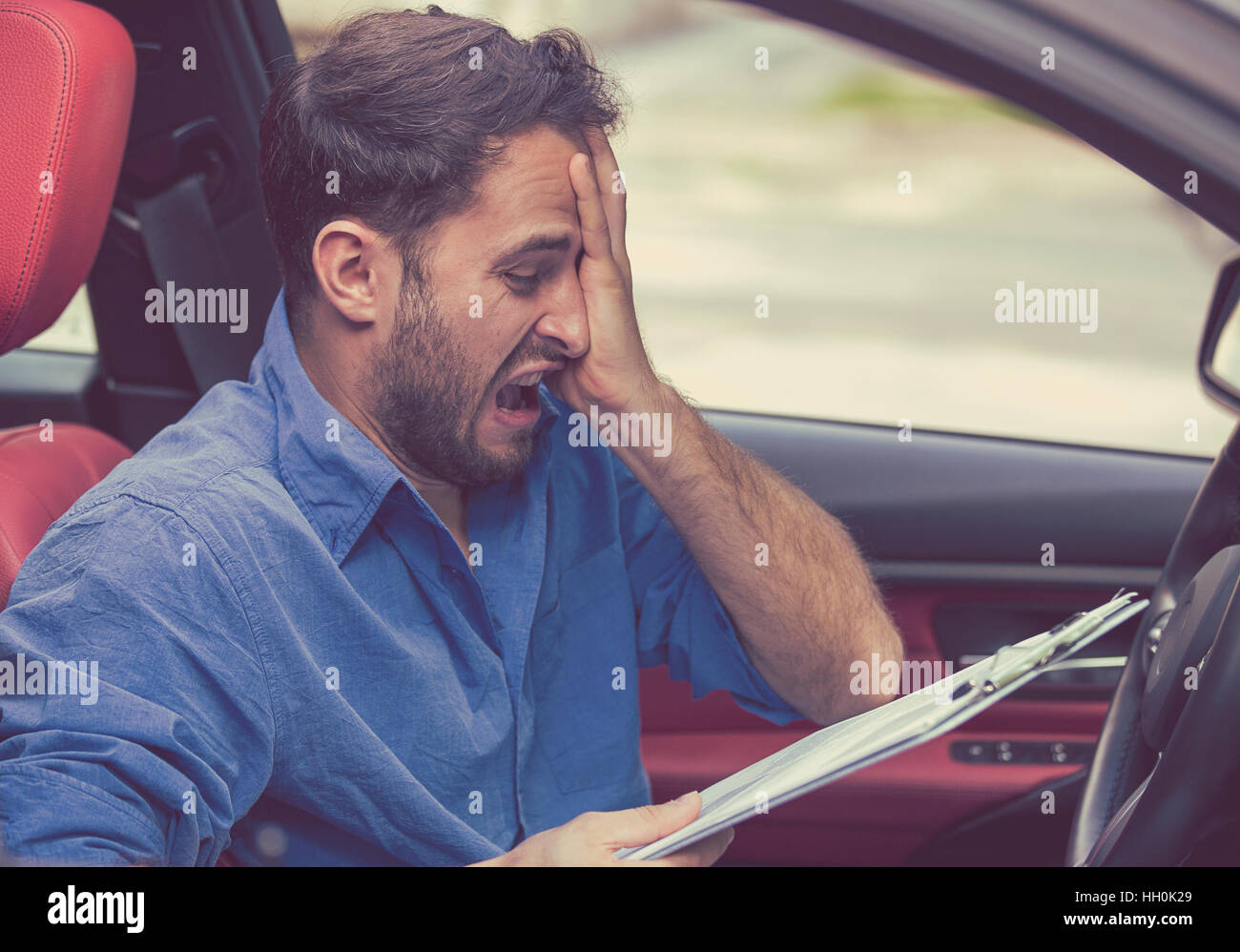 Stressed desperate man driver with papers sitting inside his car Stock ...