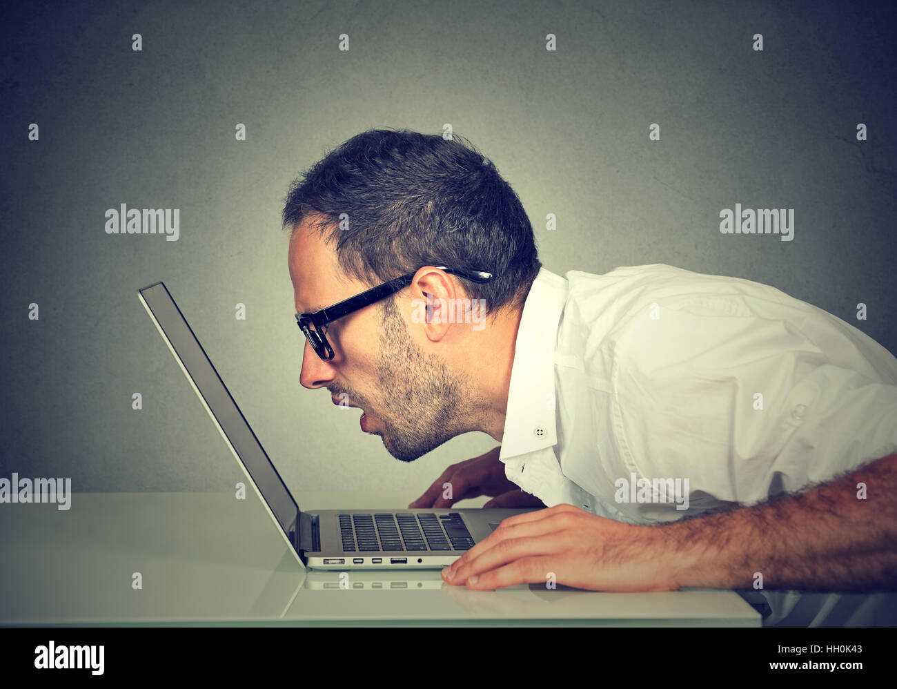 Side profile man staring closely intensely at laptop screen Stock Photo ...