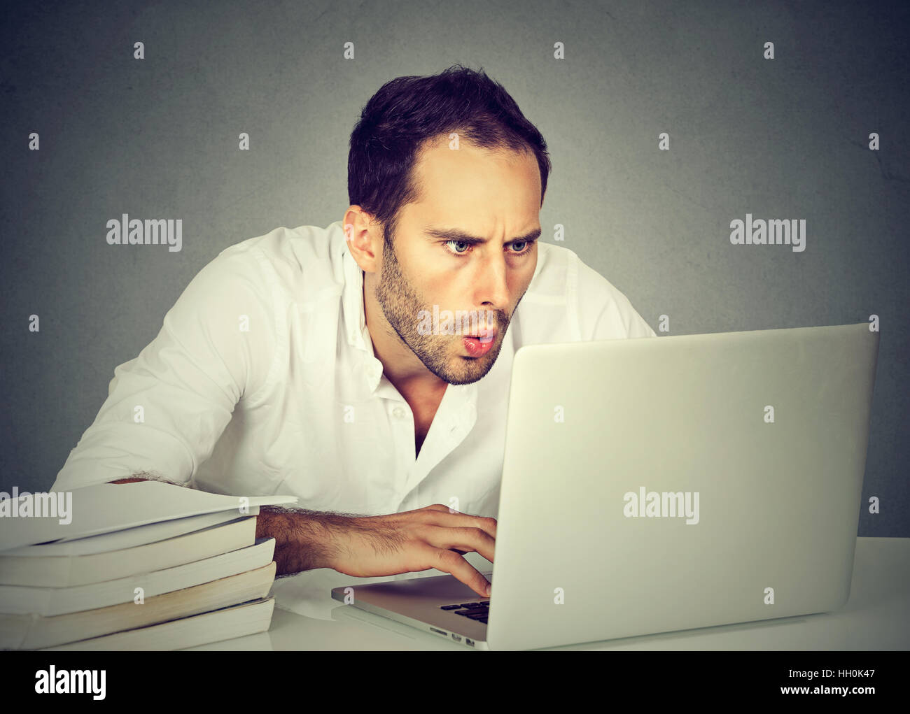 shocked business man sitting in front of laptop computer looking at ...