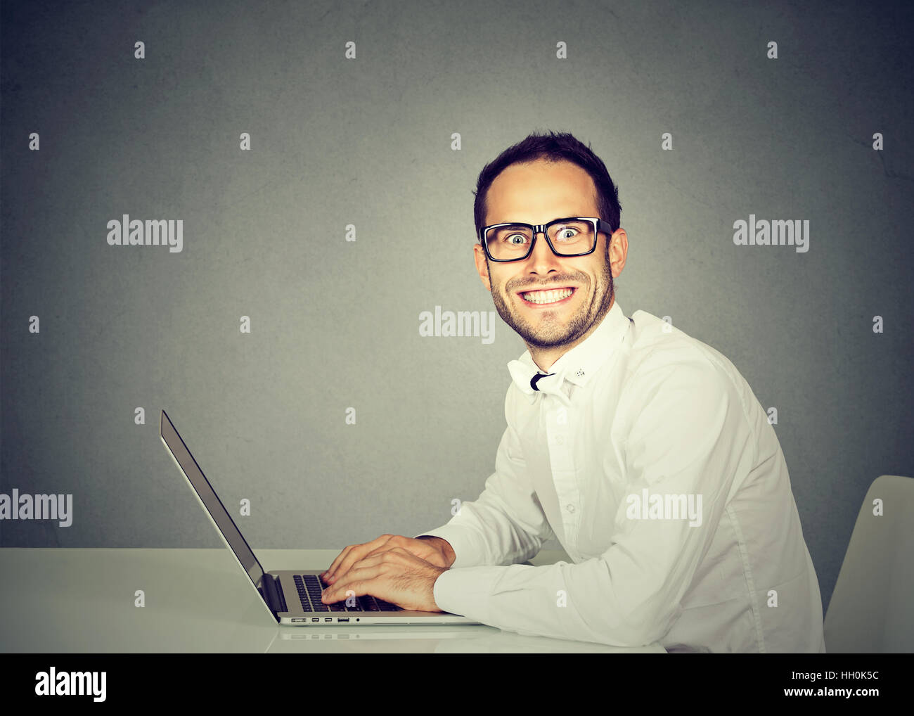 Smiling young man using a laptop Stock Photo - Alamy