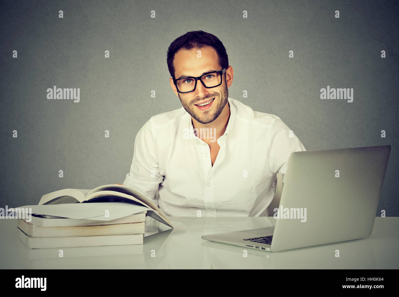 Man student using his notebook and reading books Stock Photo - Alamy